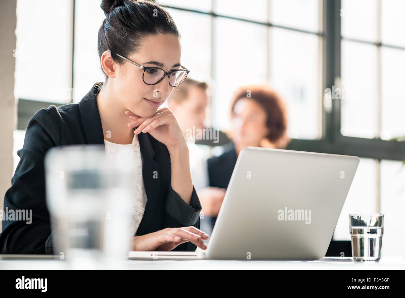 Concentrated business woman reading information on laptop Stock Photo ...