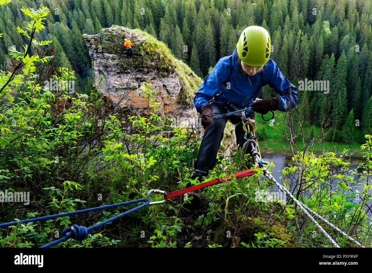 climber girl checks the safety equipment while preparing to descend ...