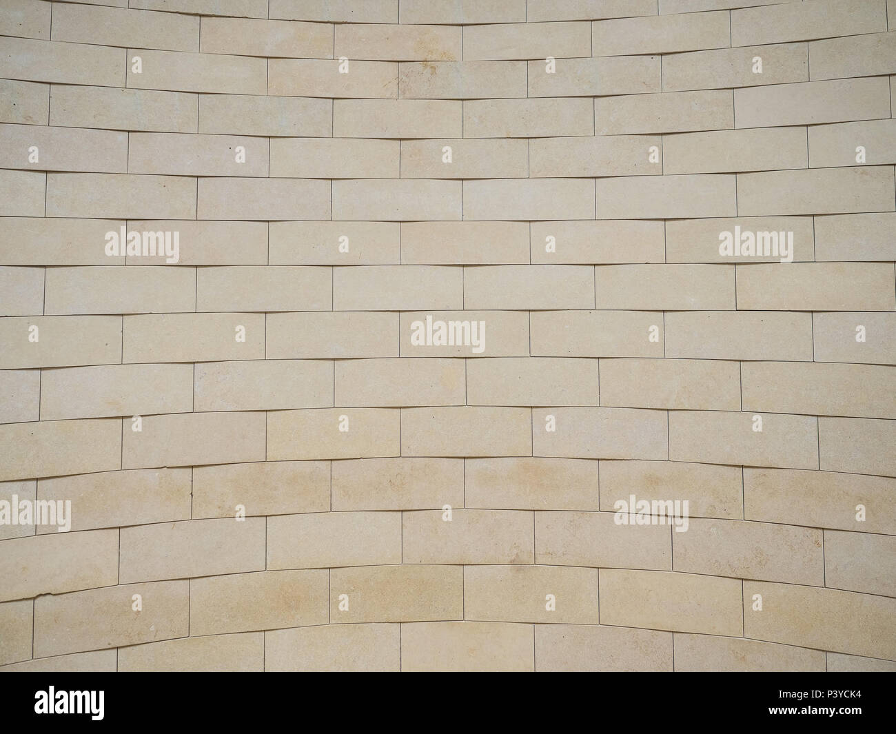 Beige brick in running bond pattern on a curved wall of a circular room ...