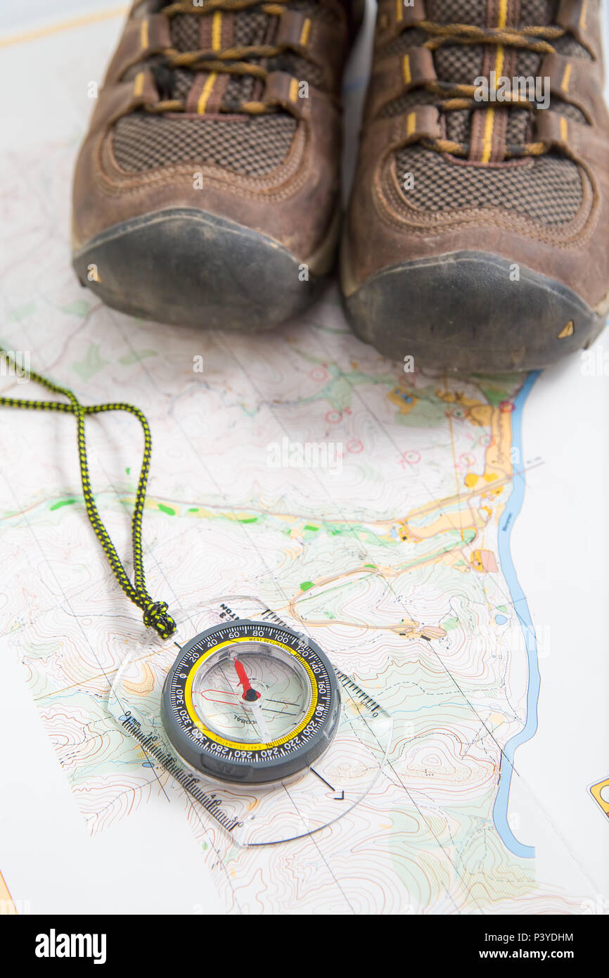 Hiking boots and a compass rest on a map ready to hike Stock Photo - Alamy