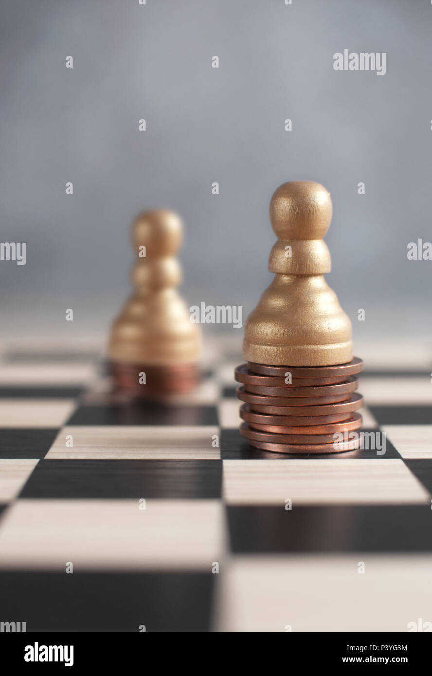 Two chess pawns on top of coins Stock Photo - Alamy