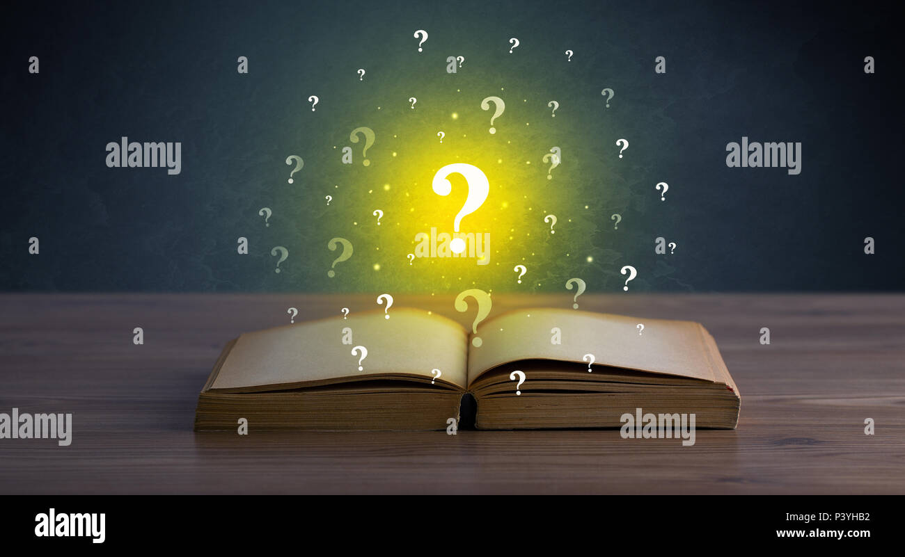 Yellow question marks hovering over open book Stock Photo - Alamy