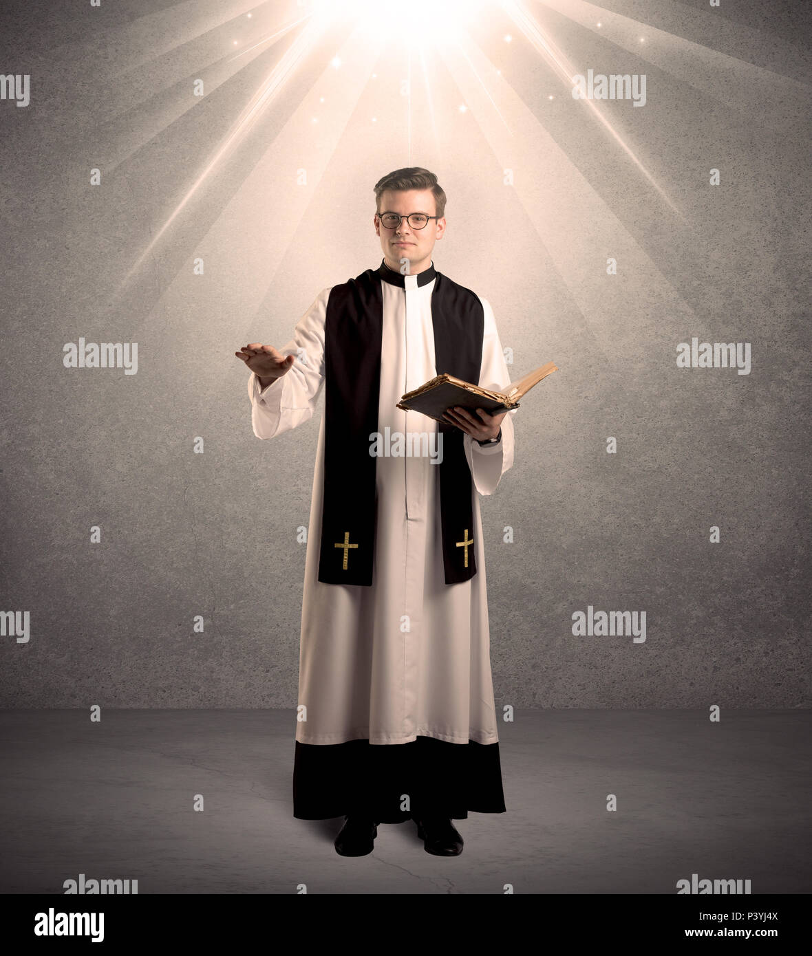 A male religious young priest in black and white dress giving his ...