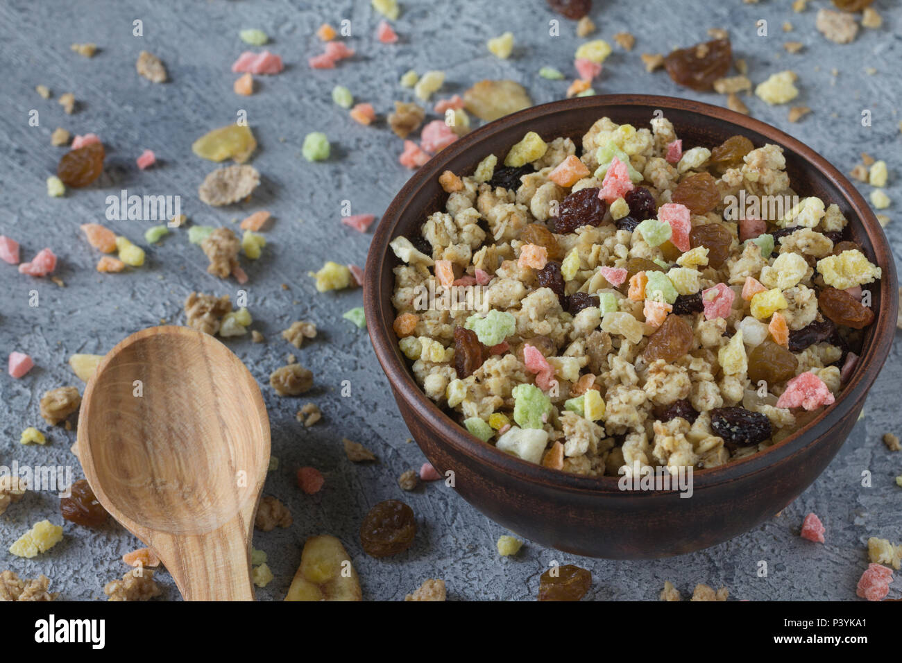 Muesli with dried fruits in a ceramic plate for breakfast on a gray ...
