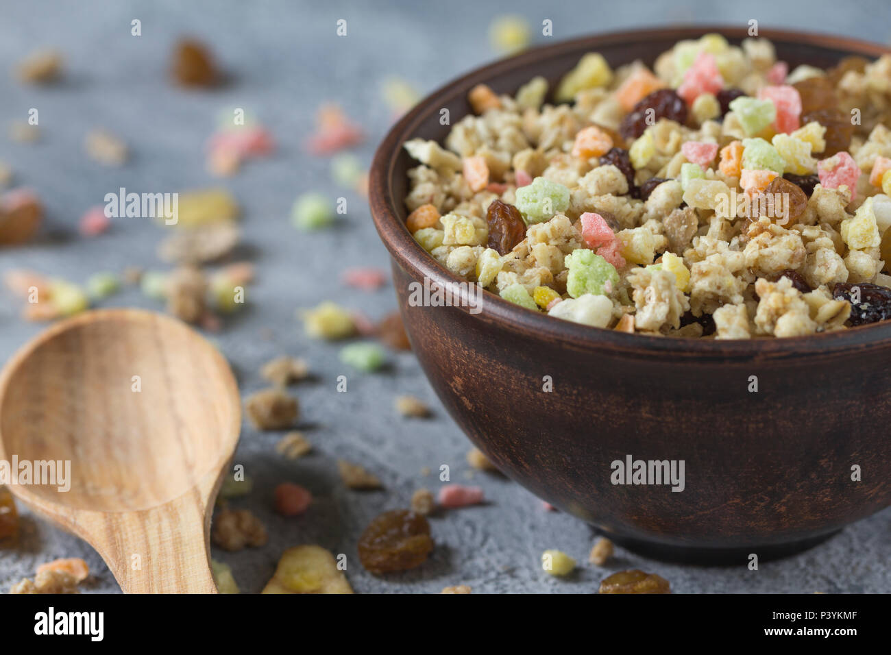 Muesli with dried fruits in a ceramic plate for breakfast on a gray ...