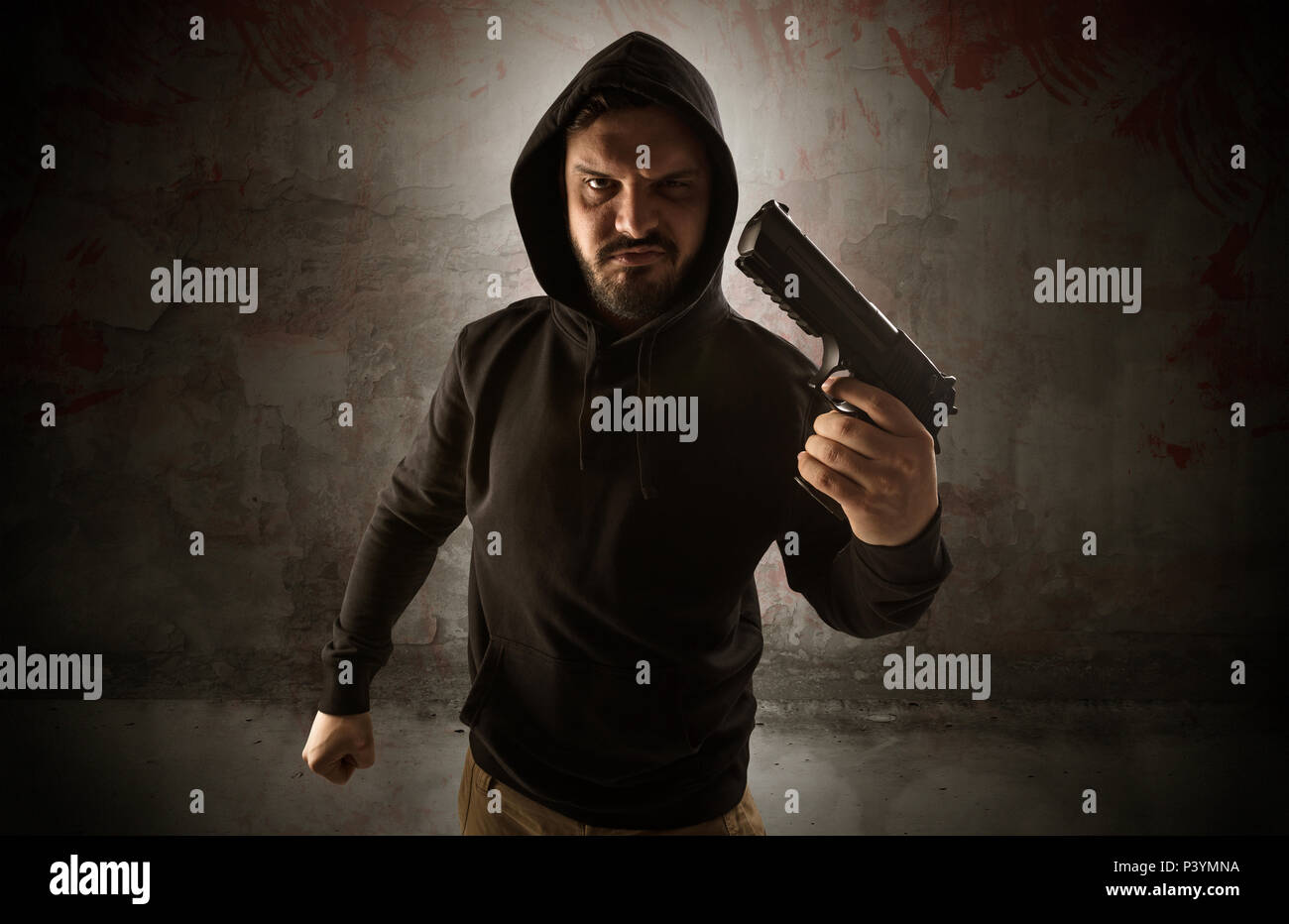 Armed rude assassin in an empty bloody room concept with gun ax ...