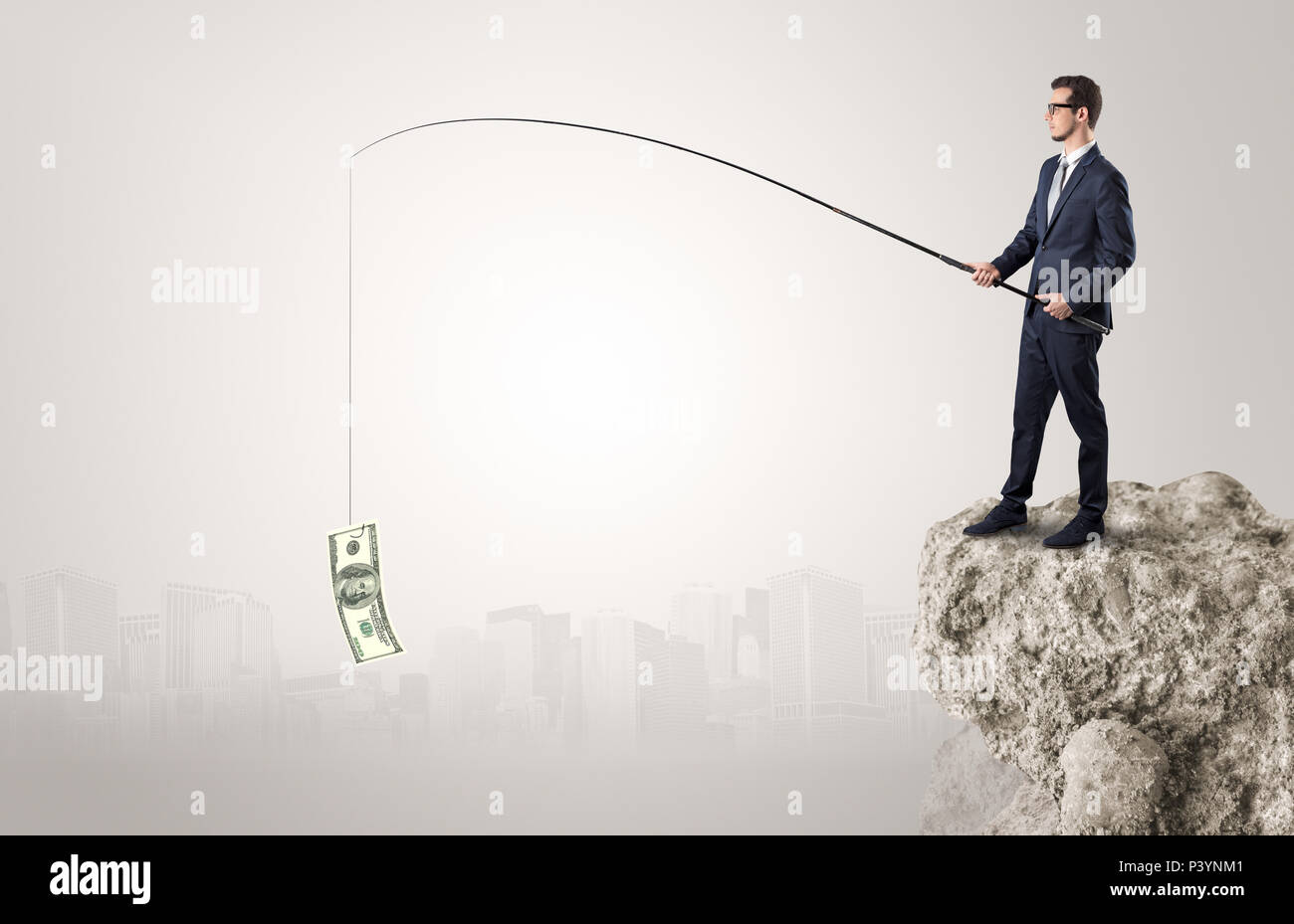 Elegant young businessman fishing cash from a huge rock Stock Photo - Alamy