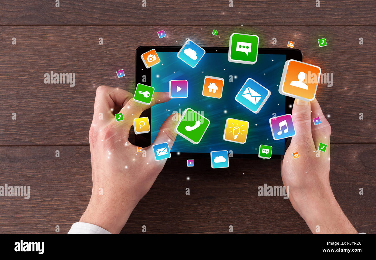 Hand using tablet with colourfull bounce application symbols and icons ...