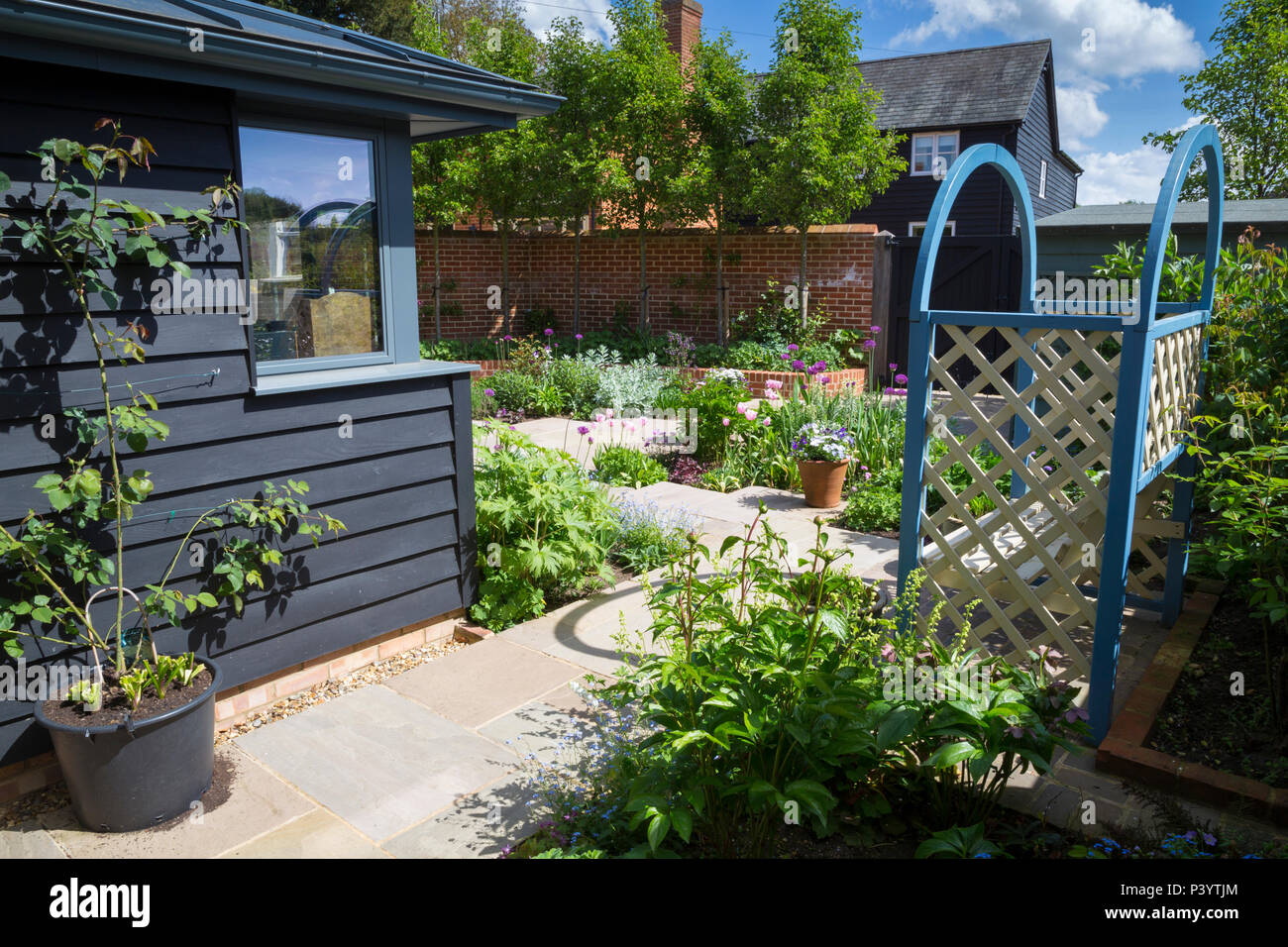 Overview of patio garden borders, blue arbour seating area and kitchen ...