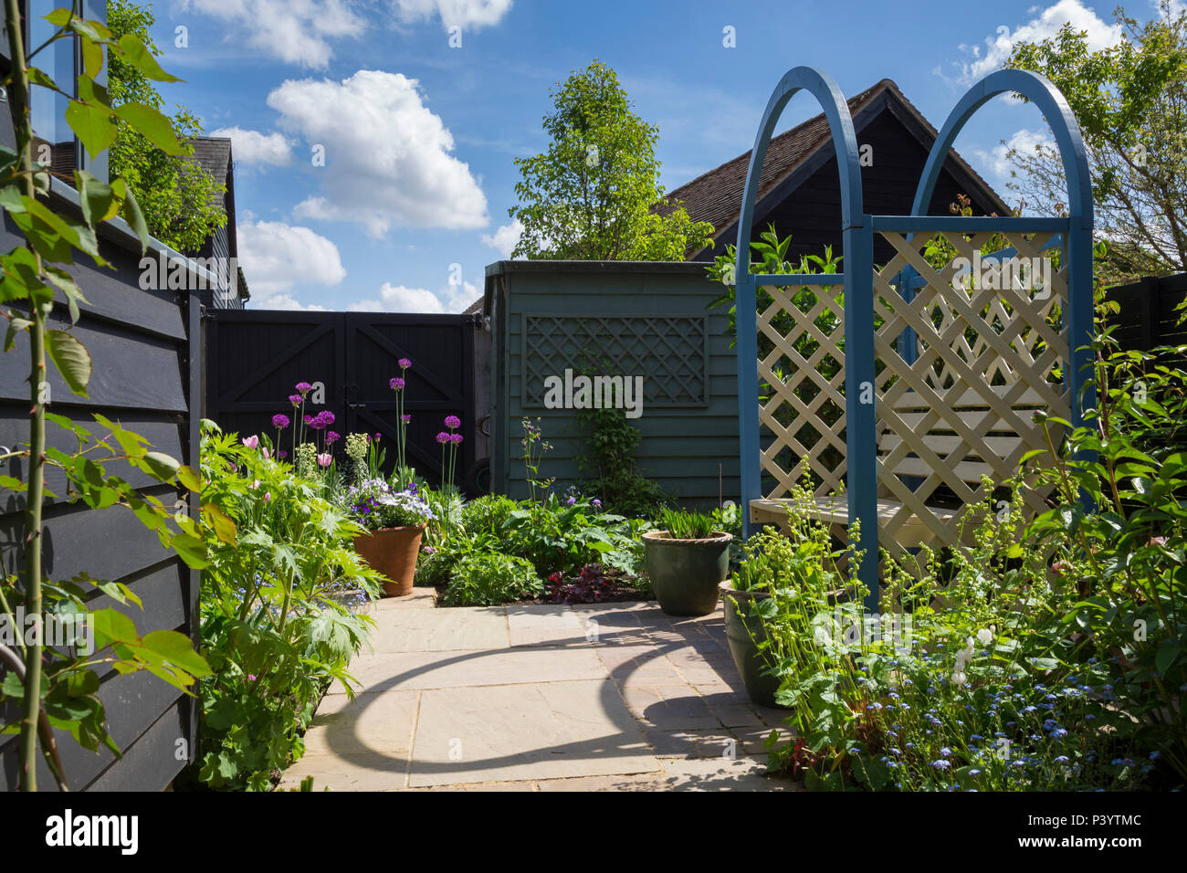 Overview of patio garden borders, blue arbour seating area and kitchen ...