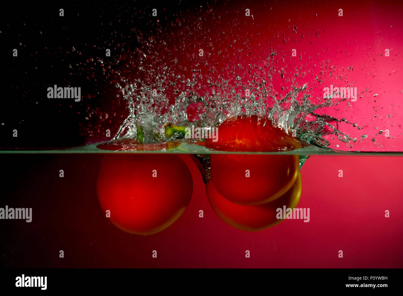 Red Tomatoes falling into the water and splashing drops Stock Photo - Alamy