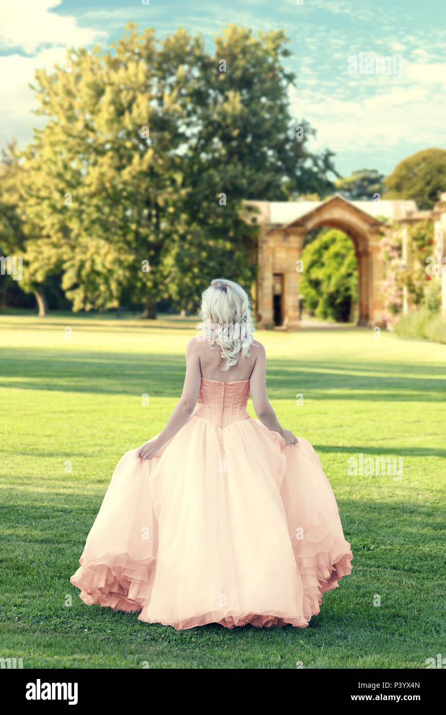 back of woman wearing evening dress walking in formal garden Stock ...