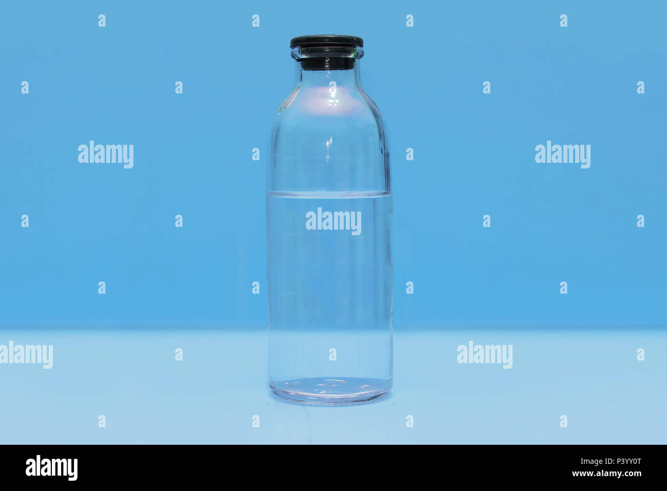 transparent medicine bottle of glass on blue background with copy space ...