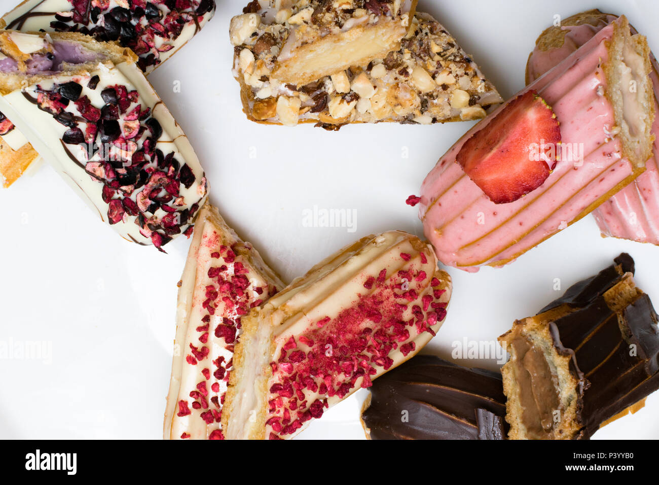 Sweet and colorful french eclairs with berrys, chocolate, nuts. Group ...