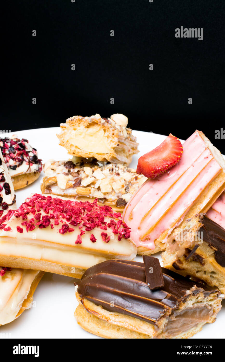 Sweet and colorful french eclairs with berrys, chocolate, nuts. Group ...