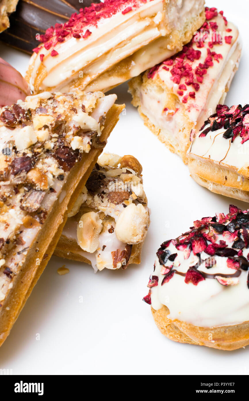 Sweet and colorful french eclairs with berrys, chocolate, nuts. Group ...
