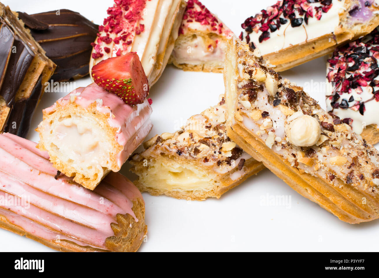 Sweet and colorful french eclairs with berrys, chocolate, nuts. Group ...