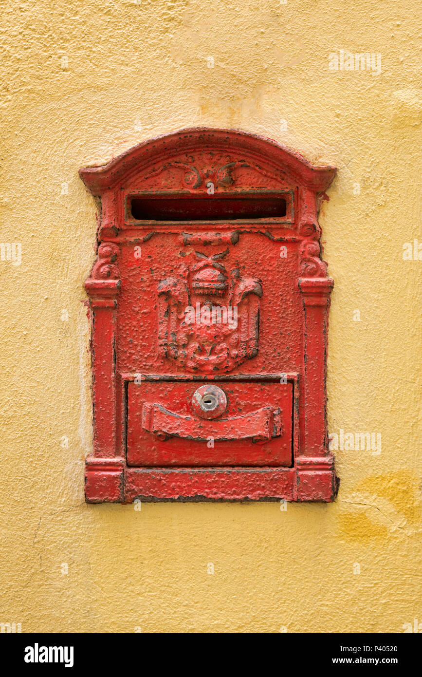 Old red Mailbox cracked and rusting on yellow wall Stock Photo - Alamy