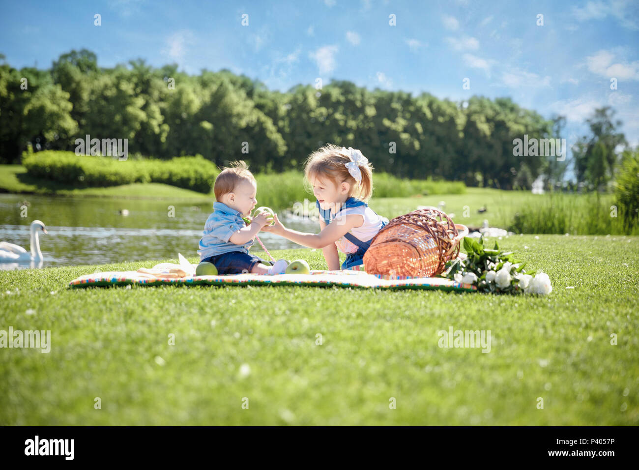Two children are sitting on green meadow and smile Stock Photo - Alamy