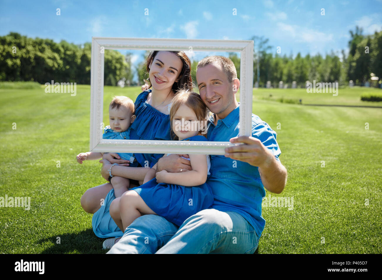 Smiling family with children looking through an empty frame Stock Photo ...