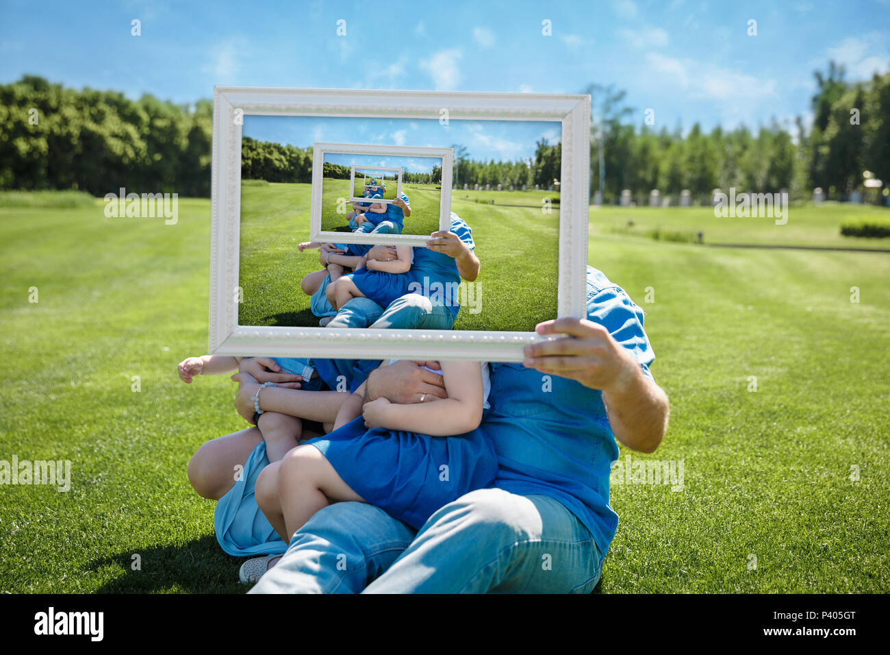 Smiling family with children looking through an empty frame Stock Photo ...