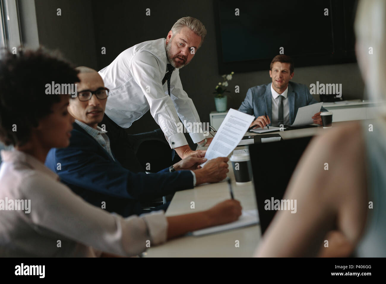 Multi-ethnic business team sitting at conference table and discussing ...