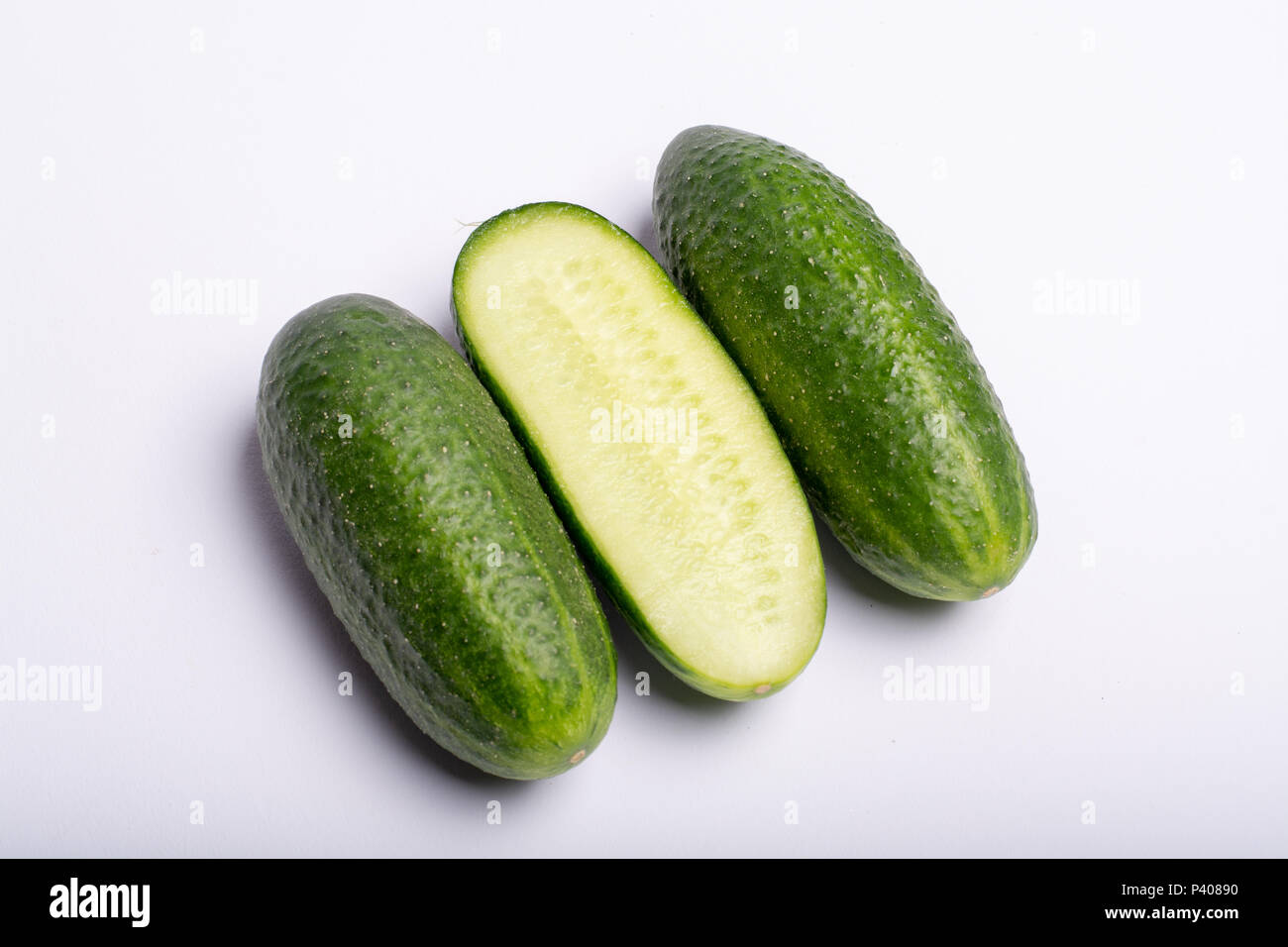 Fresh small green cucumbers whole and sliced close up copy space ...