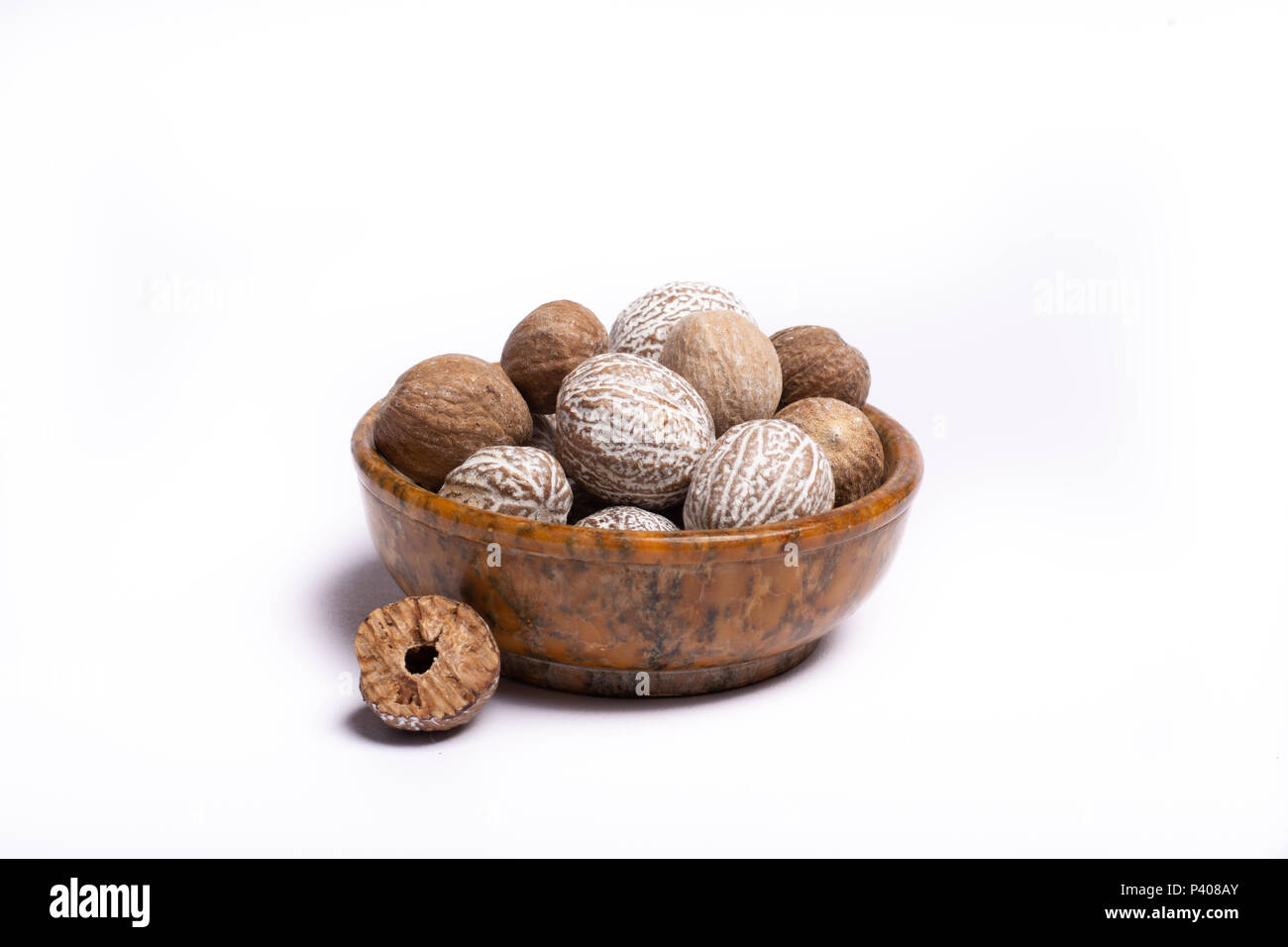 Stone bowl with nutmeg, muscat nuts, copy space close up isolated on ...
