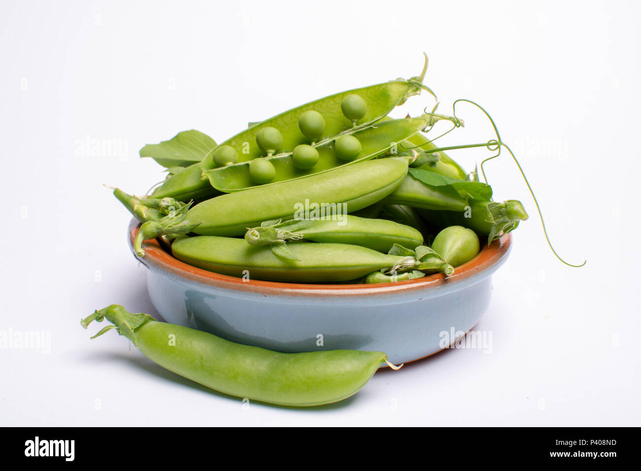 Fresh green ripe sugar snaps, sweet peas in bowl copy space close up ...