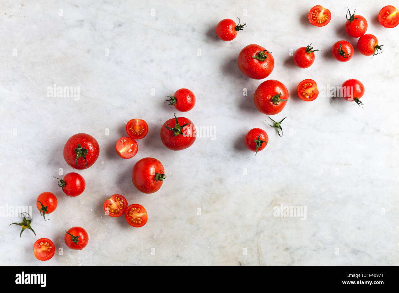 Tomatoes scattered over white marble worktop Stock Photo - Alamy