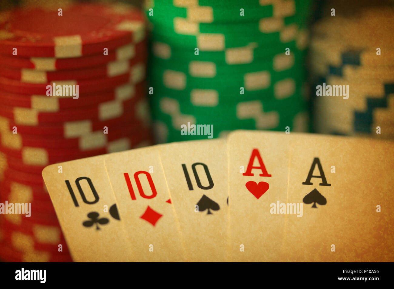 Poker hand with full house cards and jeton chips in close up on black ...
