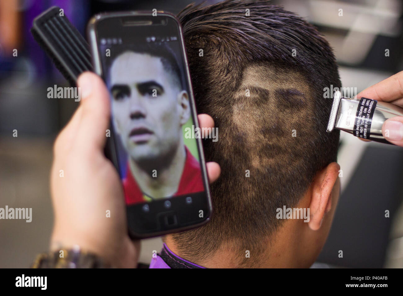 A Colombian barber sculpting the faces of football players in the heads ...