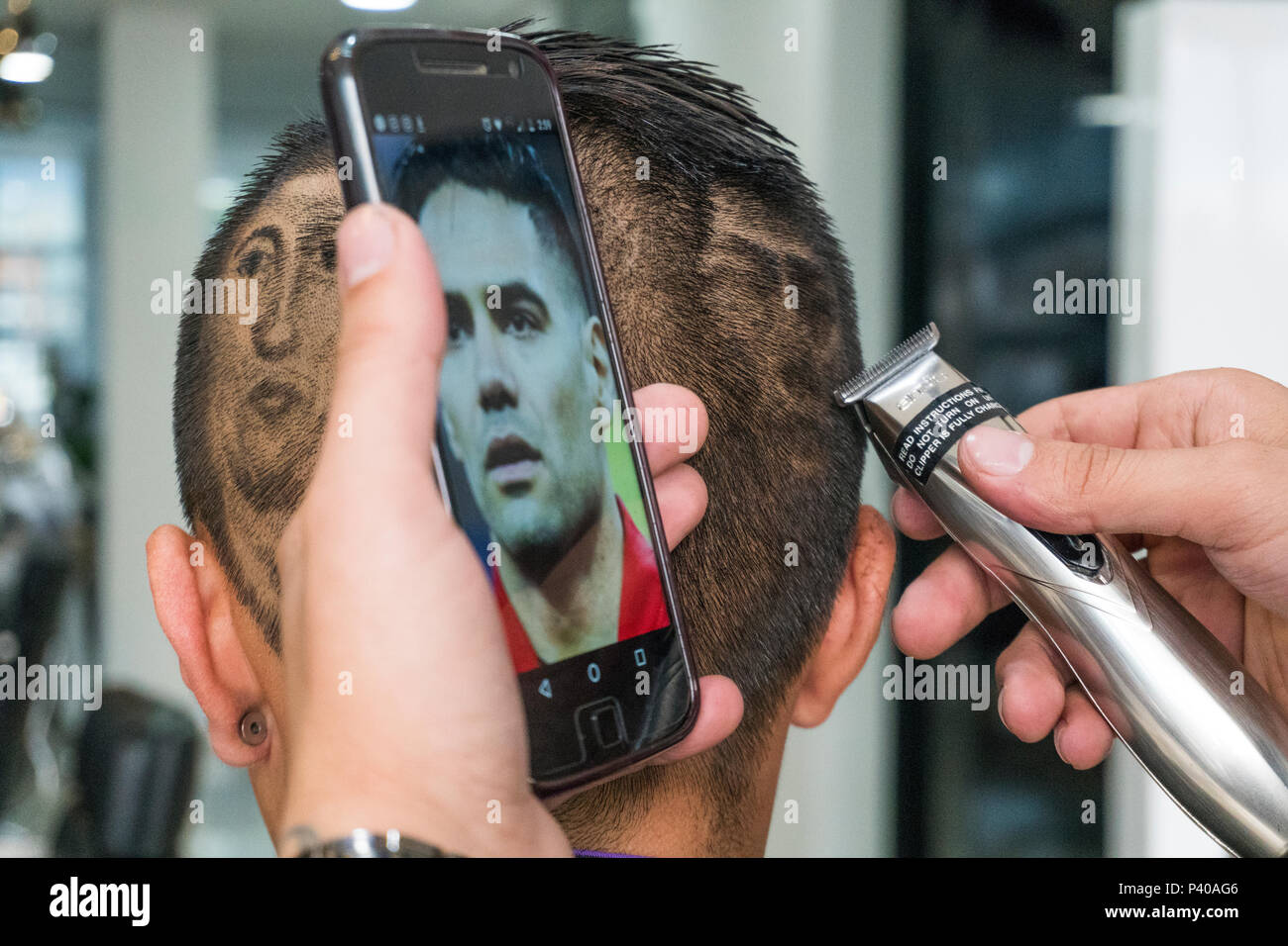 A Colombian barber sculpting the faces of football players in the heads ...