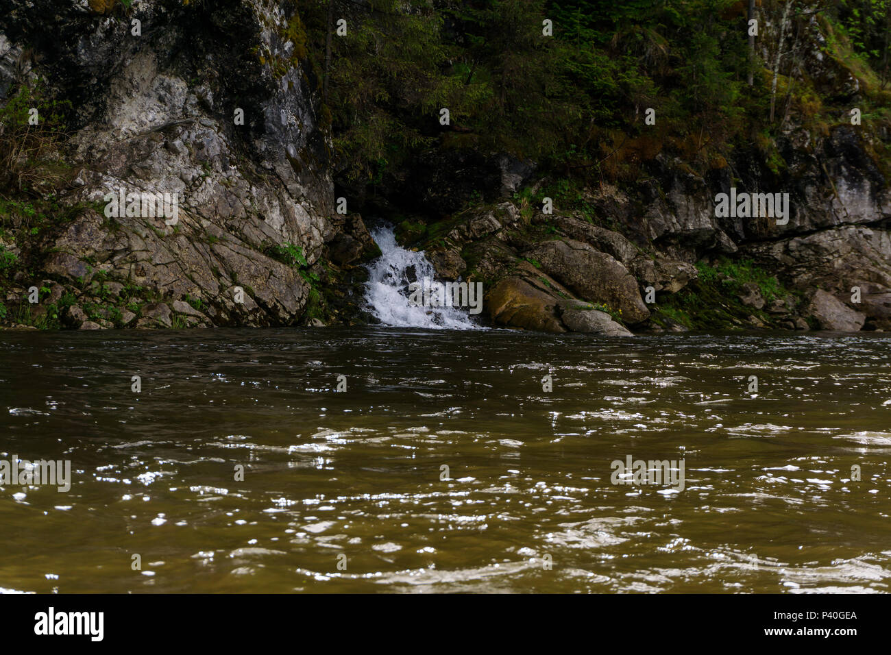 The spring follows a waterfall from the rock and flows into the river ...