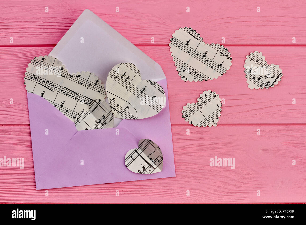 Envelope and paper hearts with music notes. Opened colorful envelope ...