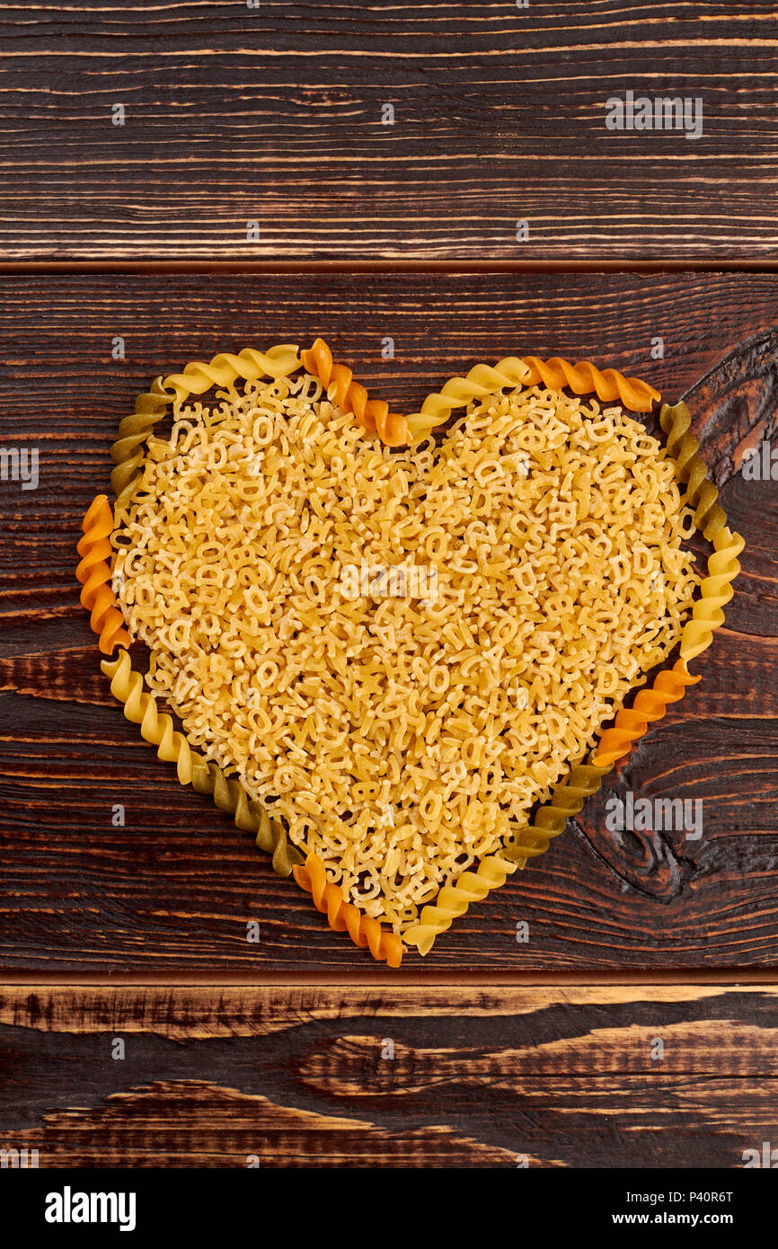 Heart shape from pasta. Uncooked pasta in a shape of heart, top view ...