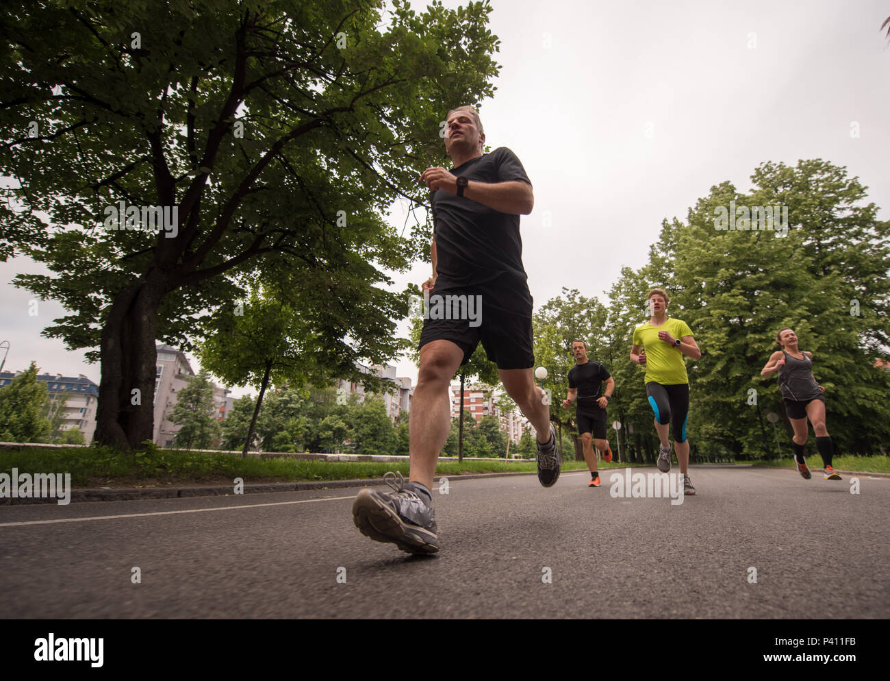 group of healthy people jogging in city park, runners team on morning ...