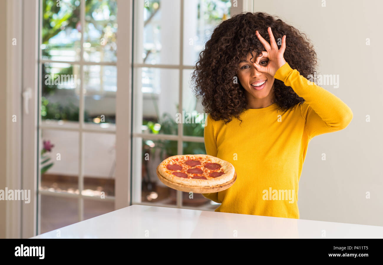 African american woman ready to eat tasty pepperoni pizza at home with ...