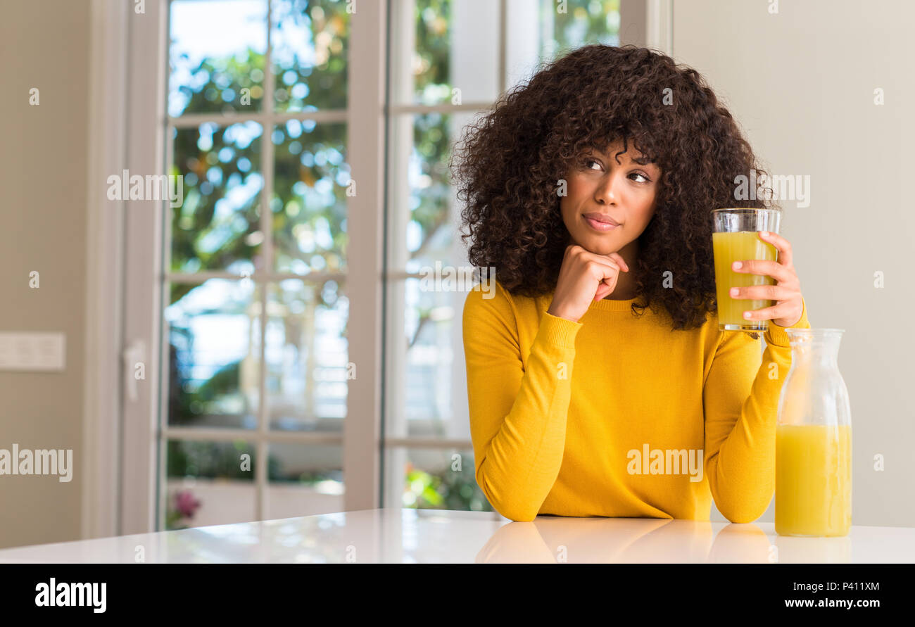 African american woman drinking healthy fruit juice at home serious ...