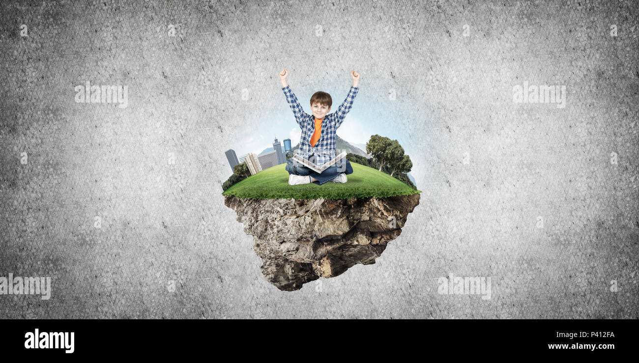 Cute boy of school age with book exploring this great world Stock Photo ...