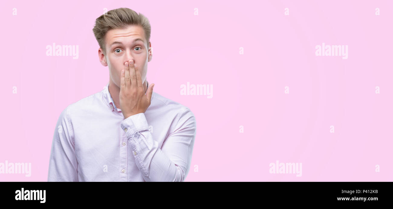 Young handsome blond man cover mouth with hand shocked with shame for ...