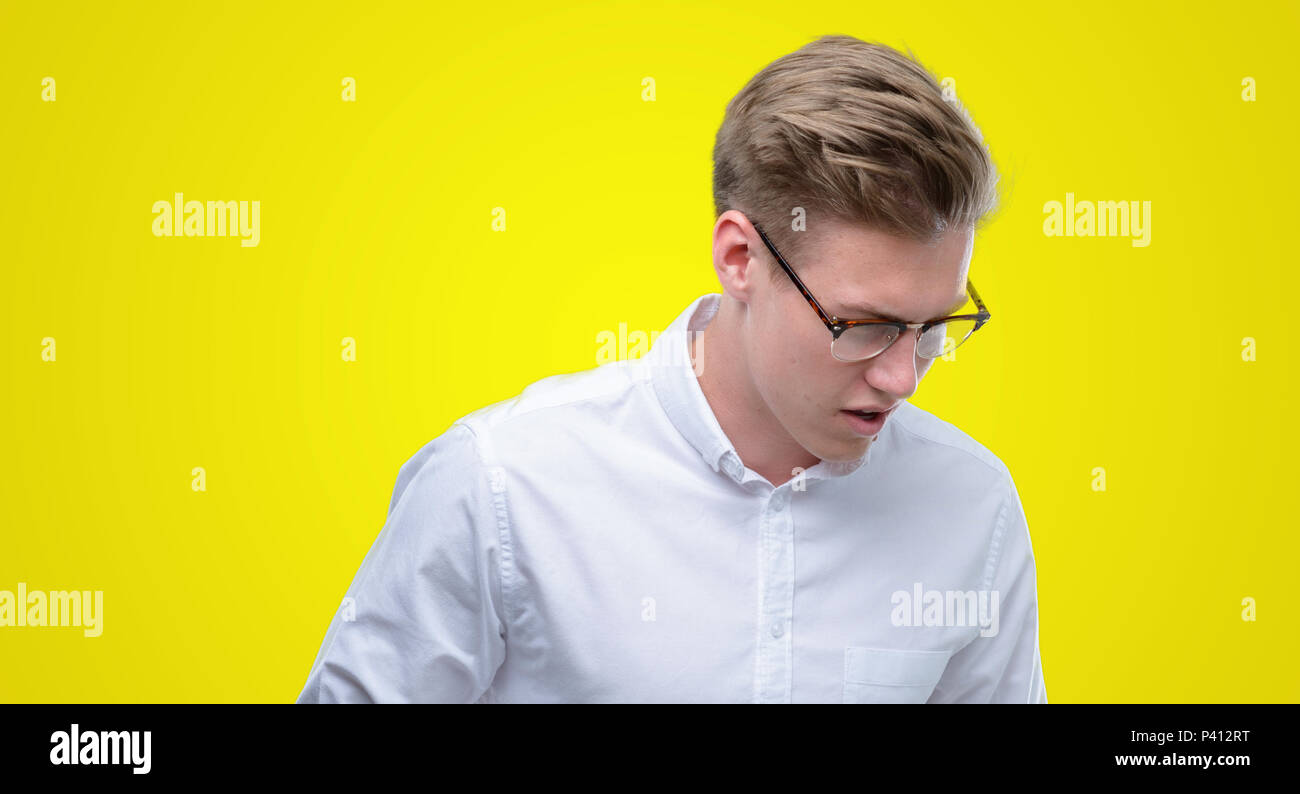 Young handsome blond man with hand on stomach because nausea, painful ...