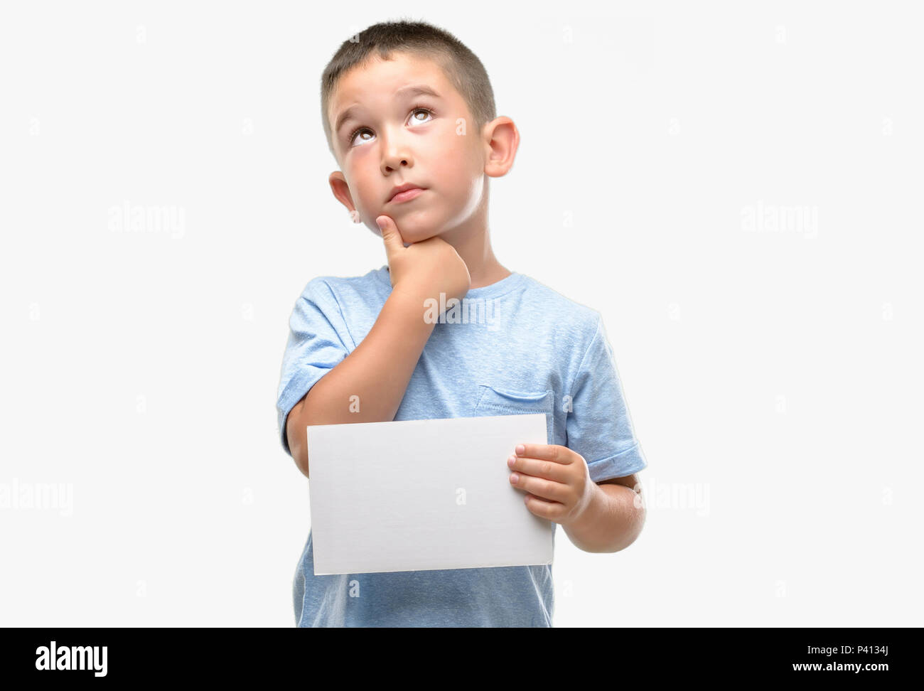 Dark haired little child holding a blank card serious face thinking ...