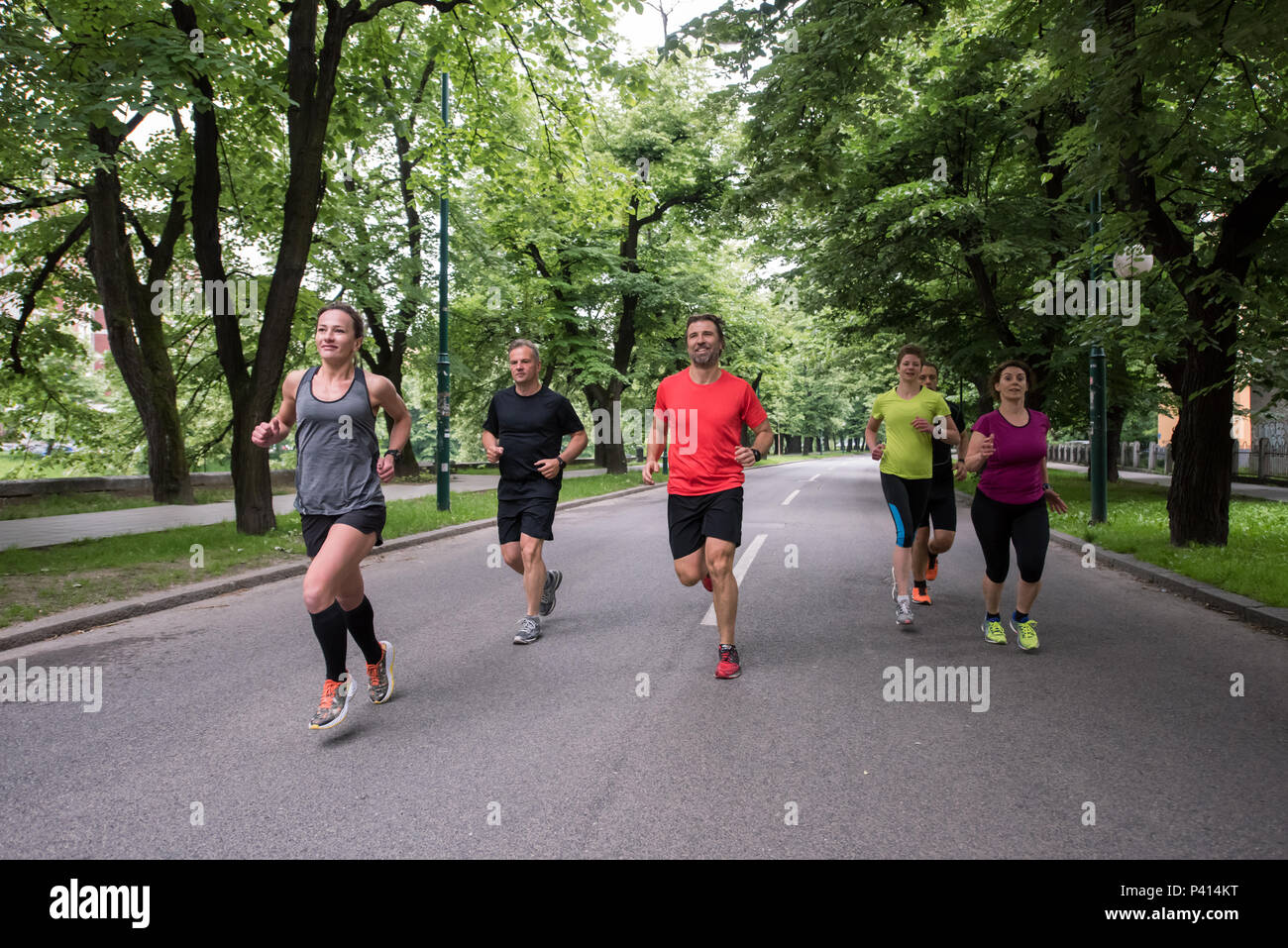 group of healthy people jogging in city park, runners team on morning ...