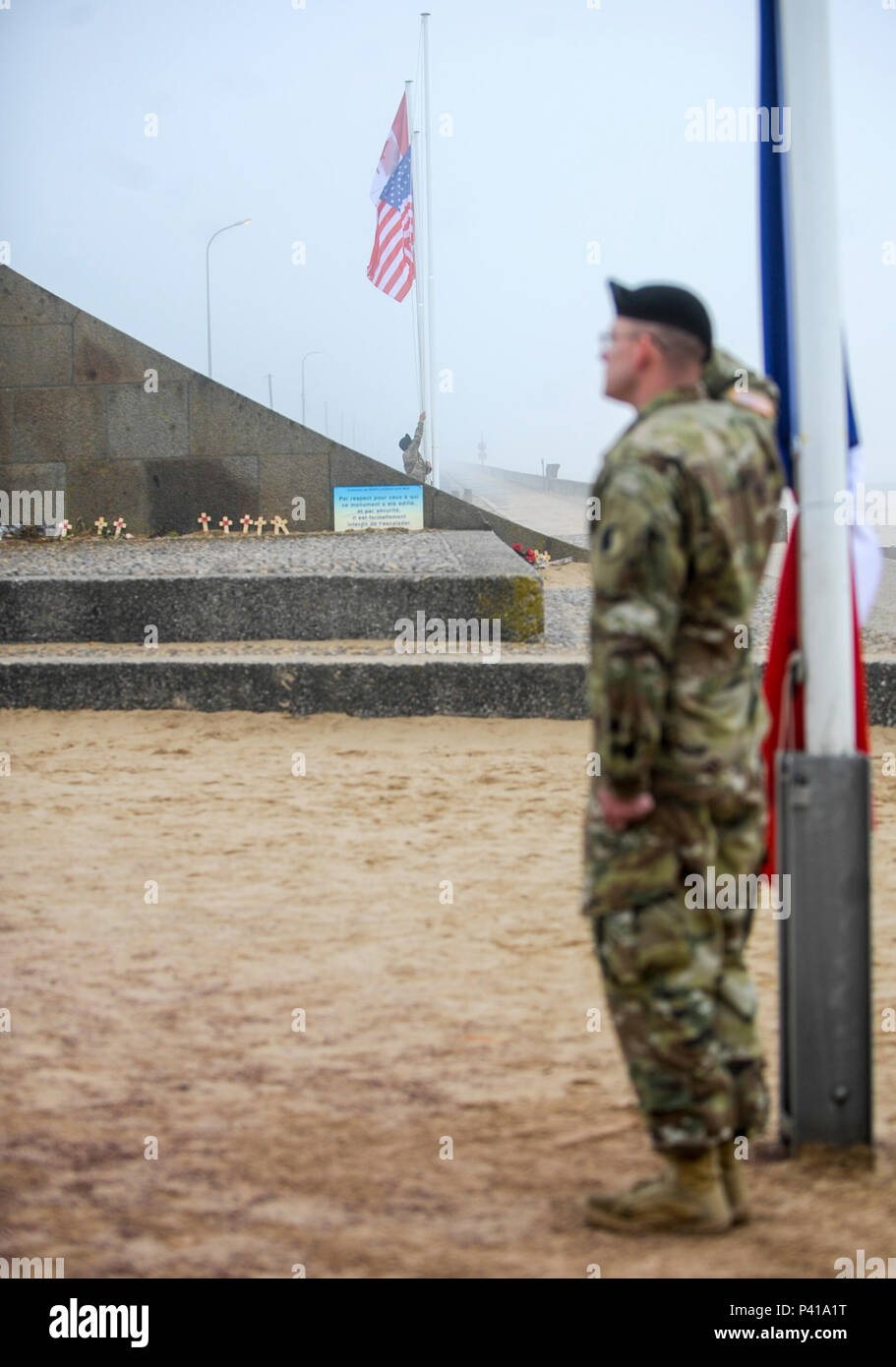 The U.S. flag is raised over Omaha Beach during a memorial ceremony ...