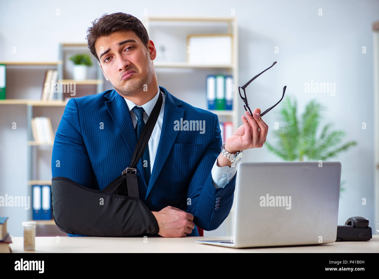 Businessman with broken arm working in office Stock Photo - Alamy