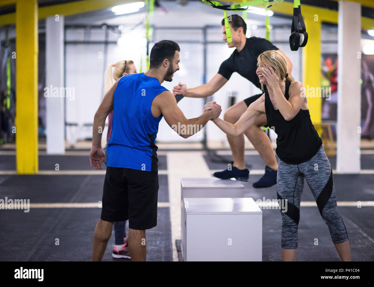 group of young healthy athletic people training jumping on fit box at ...
