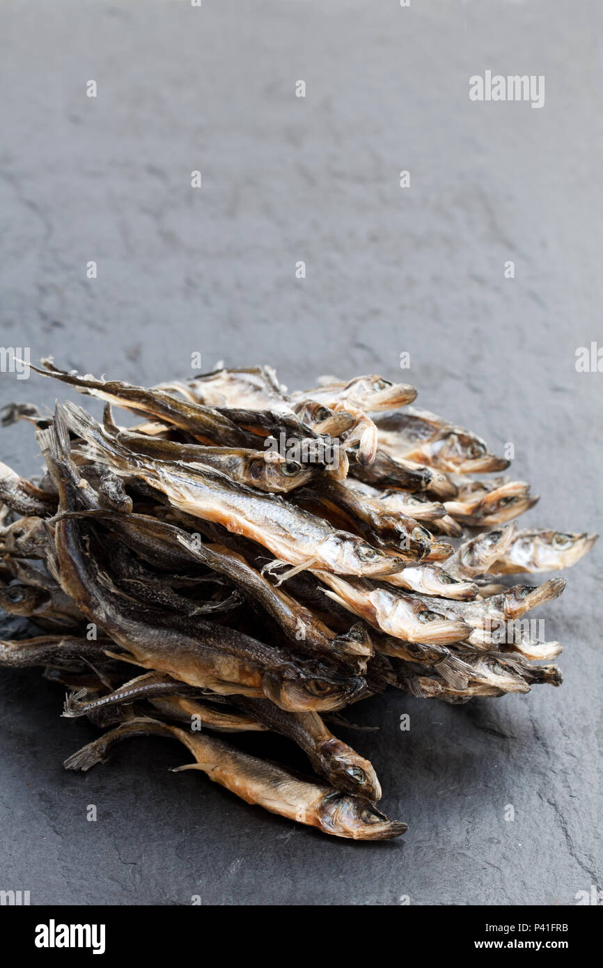 Heap of dried fishes on black stone background Stock Photo - Alamy