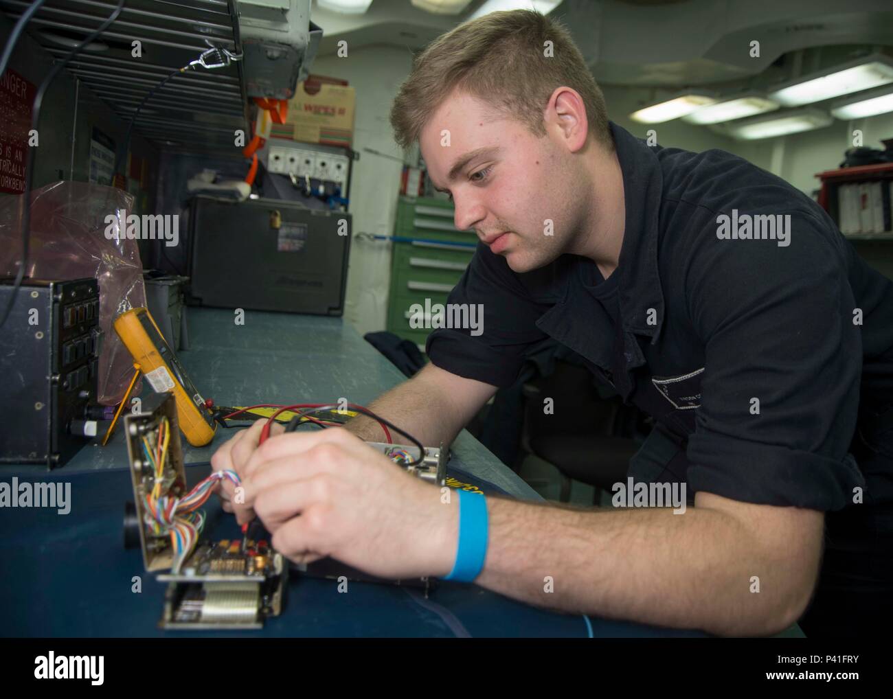 An Aviation Electrician’s Mate inspects wire continuity inside a blade ...