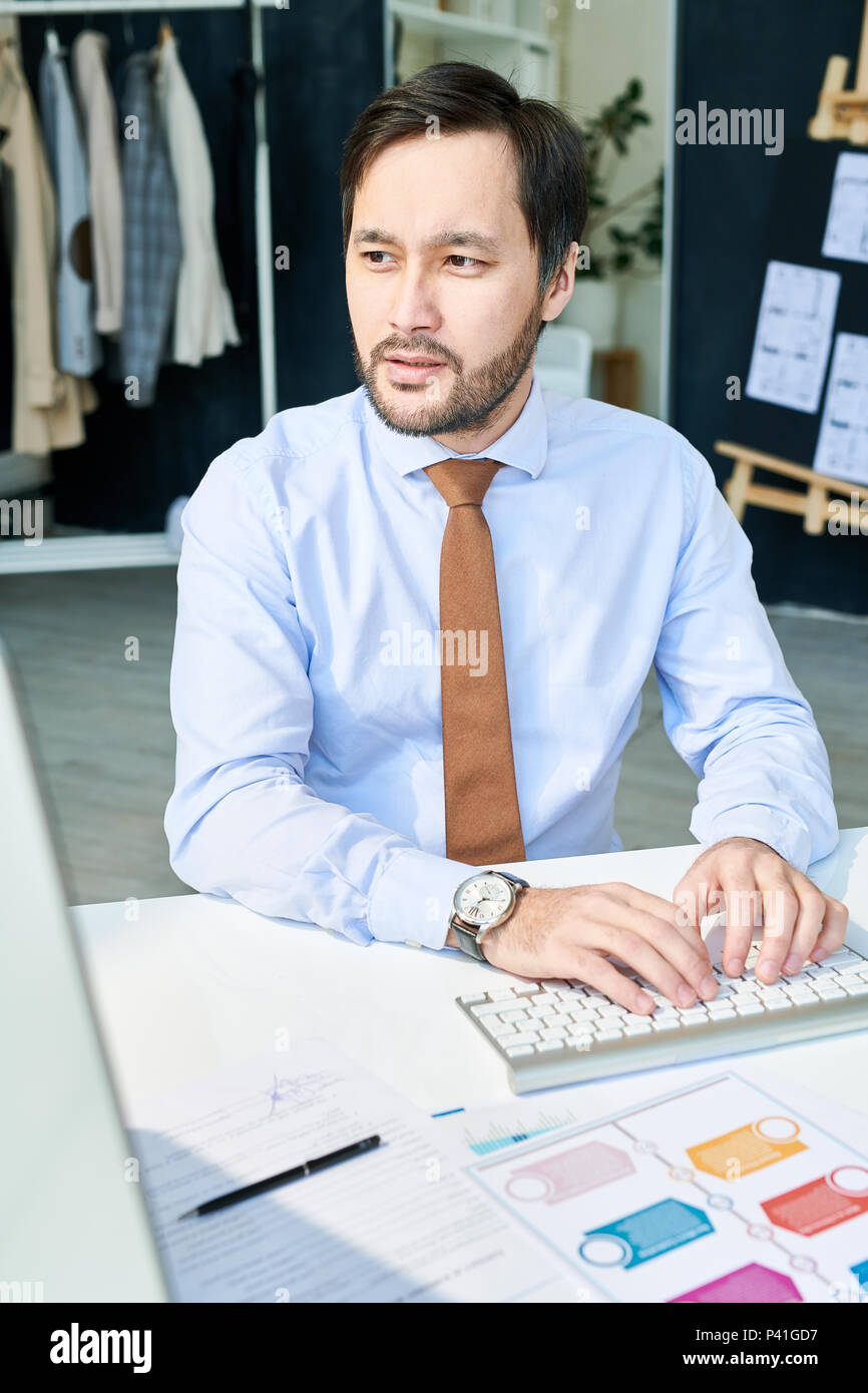 Thoughtful man typing on keyboard Stock Photo - Alamy